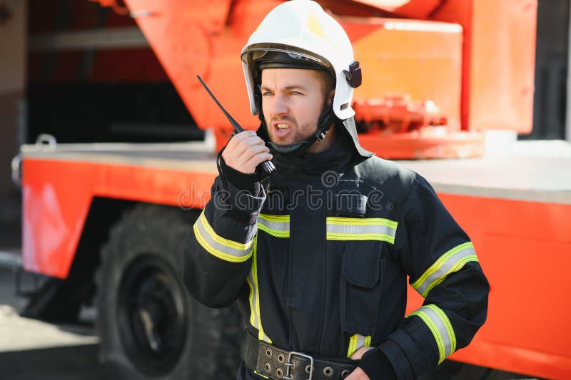 Fireman in a Protective Uniform Standing Next To a Fire Truck and ...