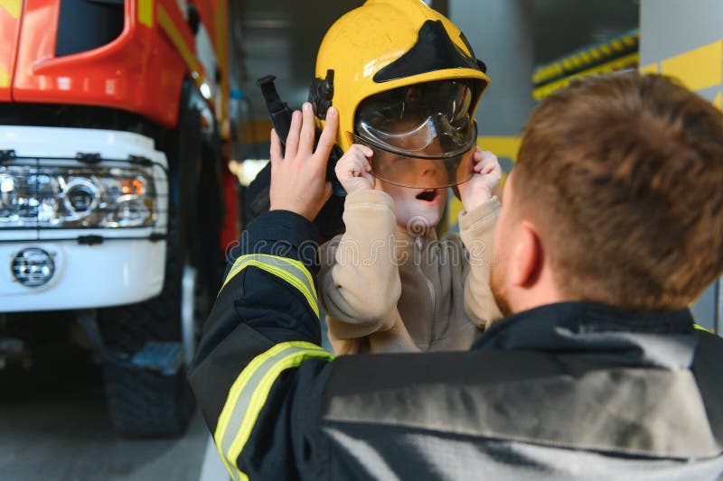 A Fireman Shows His Work To His Young Son. a Boy in a Firefighter& X27 ...