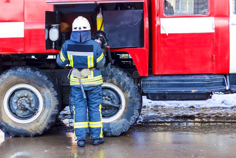 A Fireman Standing Near a Red Fire Engine and Holding an Oxygen Stock ...