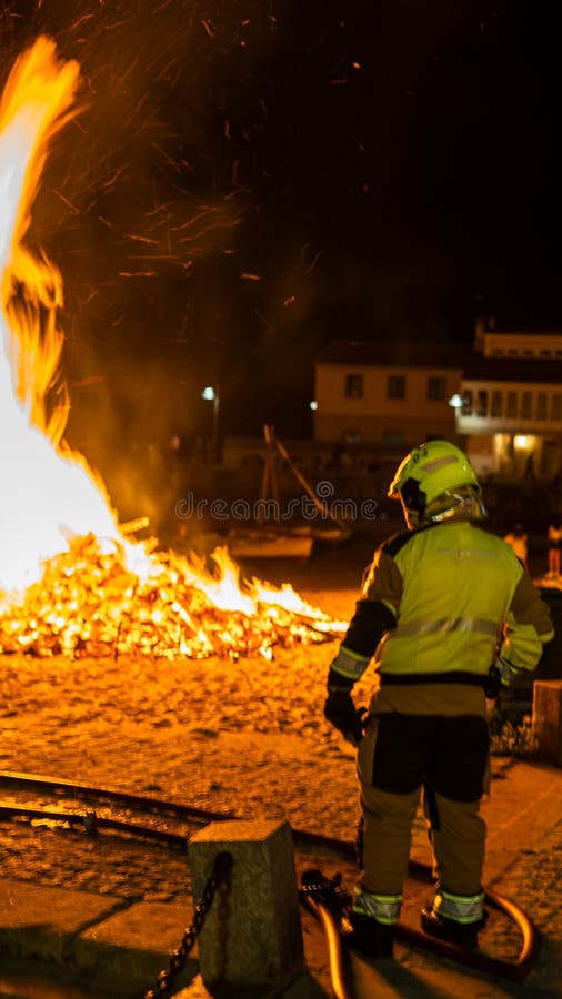 Fireman watching a bonfire stock image. Image of flames - 283475123