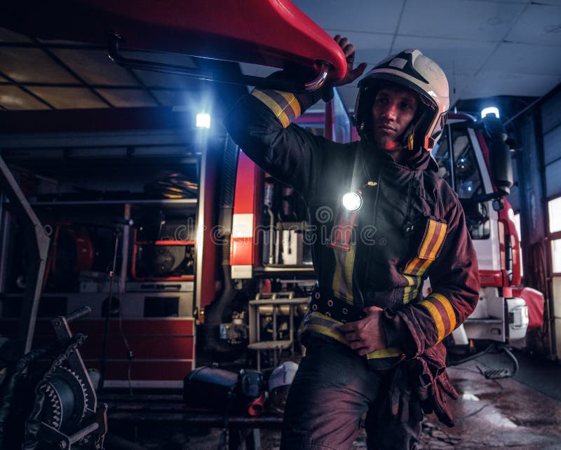 A Fireman Wearing a Protective Uniform with Flashlight Included Working ...