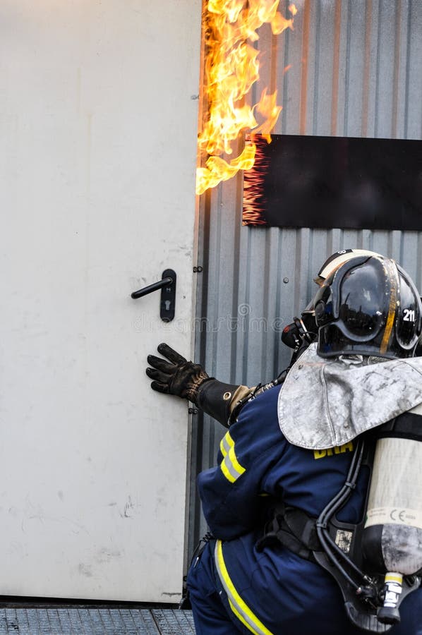 Firefighter Opening Door To Burning Building Stock Image - Image of ...