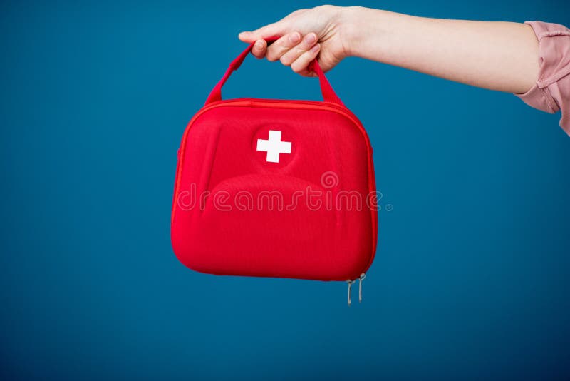 First Aid Kit on the Blue Background Stock Photo - Image of holding ...