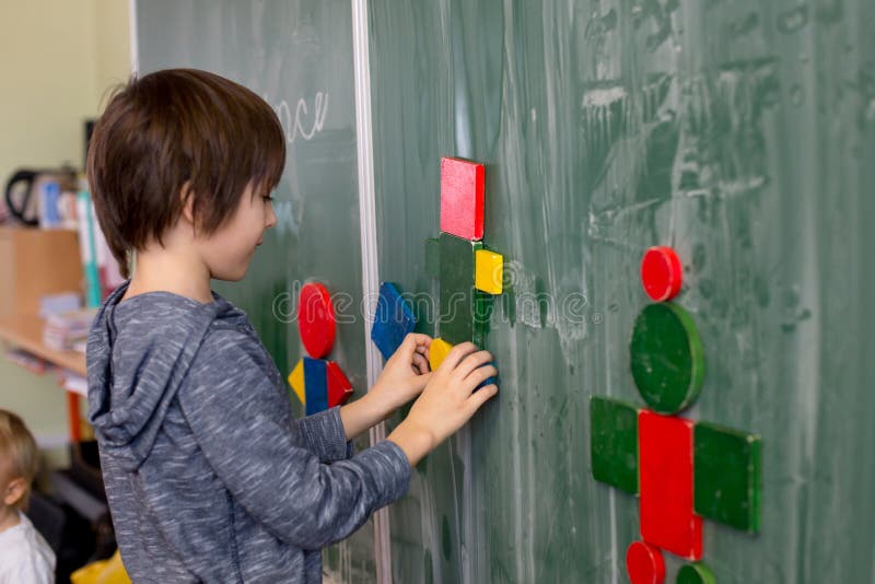 First Grade Child, Learning Math, Shapes and Colors at School Stock ...