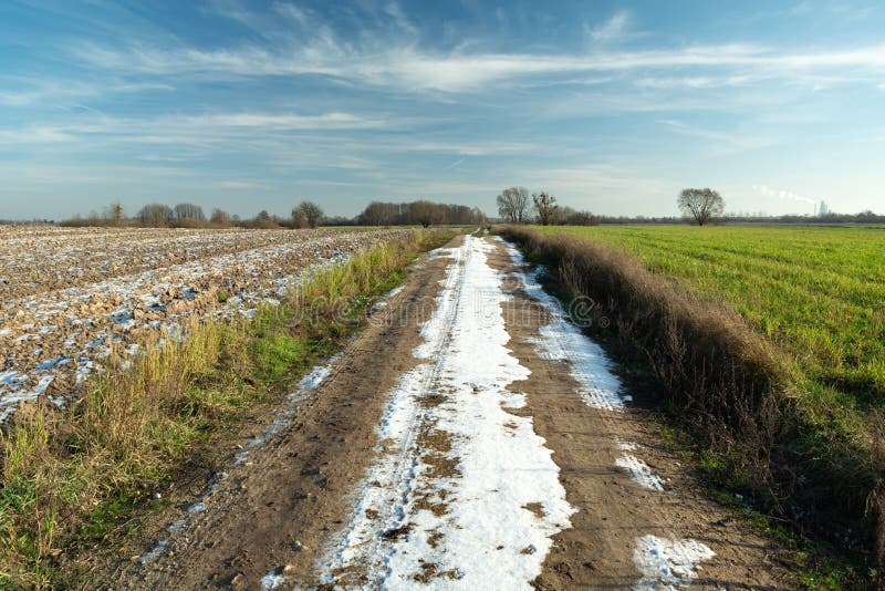 First Snow on a Dirt Road through Fields and Clouds on the Sky Stock ...