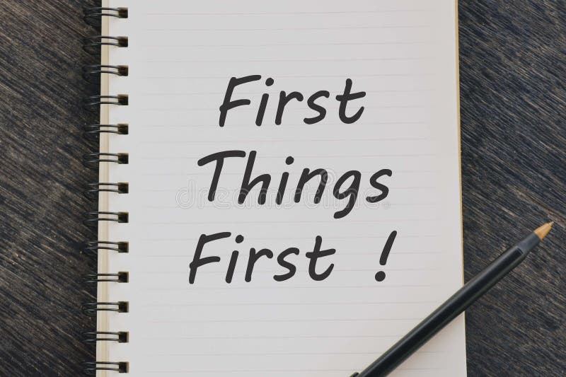 First Things First Written on Notepad with Pen on Wooden Desk. Stock ...
