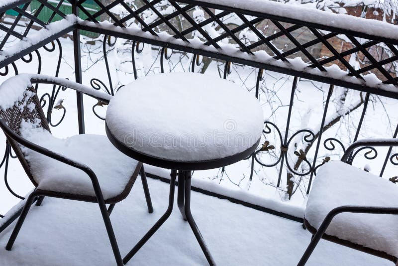 The First White Fluffy Snow on the Table and Chairs on the Wrought-iron ...