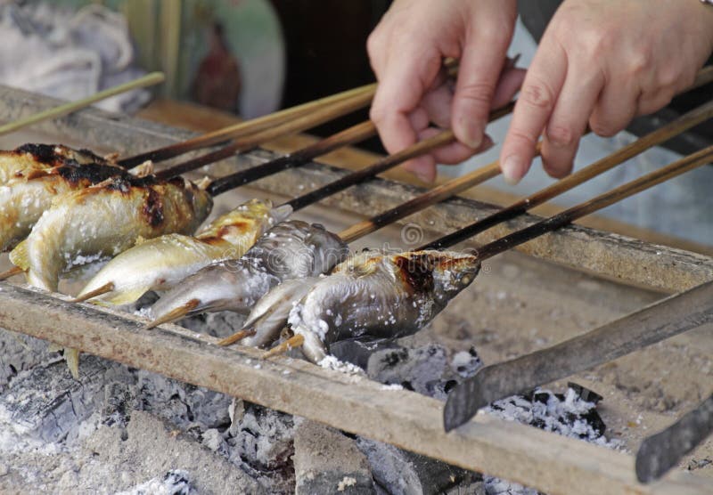 Fish Being Grilled Over Hot Ash on Sticks Stock Photo - Image of dinner ...