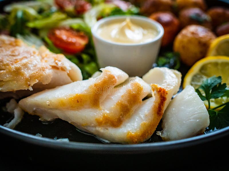 Fish Dish - Fried Cod Fillet with Potatoes and Vegetable Salad on Black ...