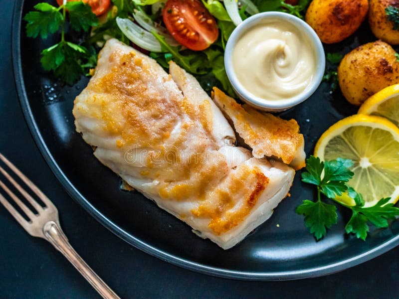 Fish Dish - Fried Cod Fillet with Potatoes and Vegetable Salad on Black ...