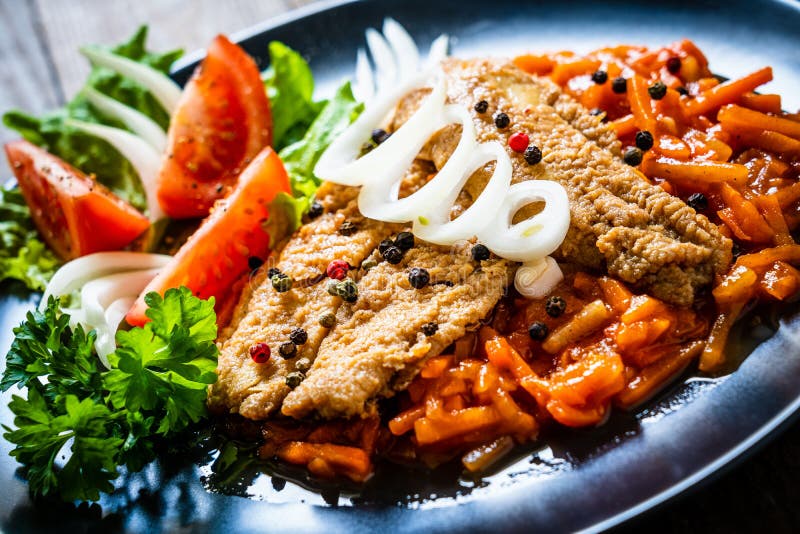 Fish Dish - Fried Fish Fillet on Vegetable Sauce on Wooden Table Stock ...