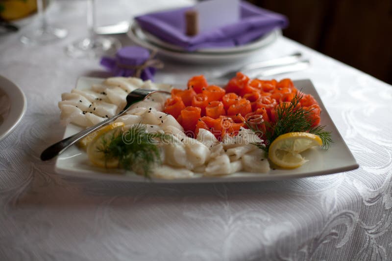 Fish Dish with Lemon, Fresh Green Leaves in the Restaurant. Stock Photo ...