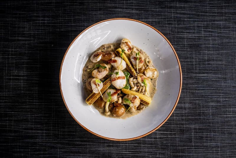 A Fish Dish in a White Plate with Baby Corn and Cress. Stock Photo ...