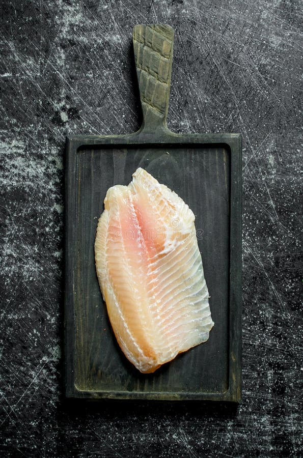 Fish Fillet on a Black Cutting Board Stock Photo - Image of halibut ...