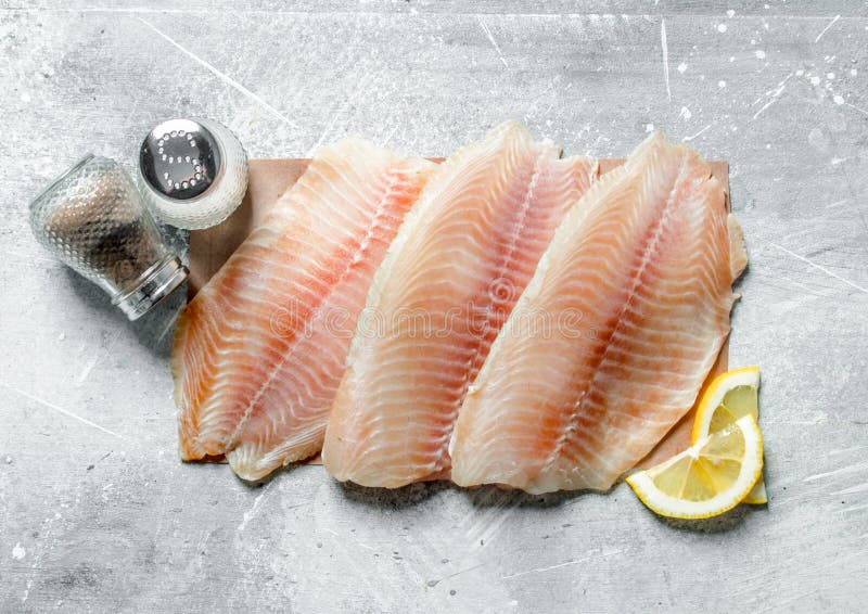 Fish Fillet on Paper with Spices and Lemon Pieces Stock Image - Image ...