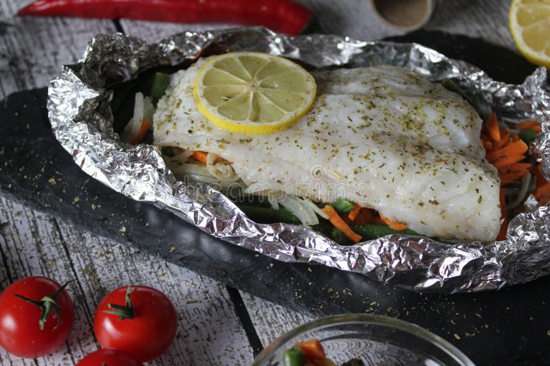Fish in Foil on a Stone Baked with Lemon and Vegetables Stock Photo ...