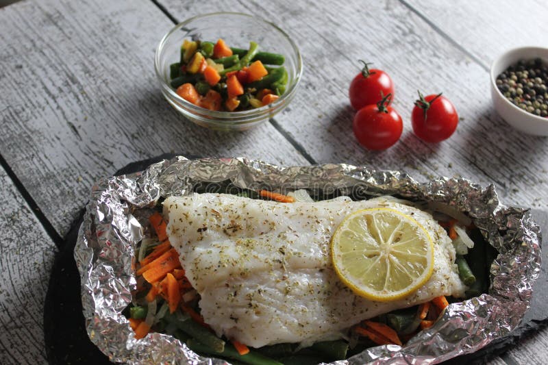 Fish in Foil on a Stone Baked with Lemon and Vegetables Stock Photo ...