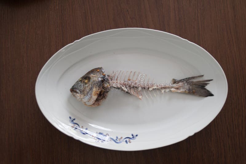 Fish Bone Left Overs with a Sliced Lemon on a White Oval Plate. Stock ...