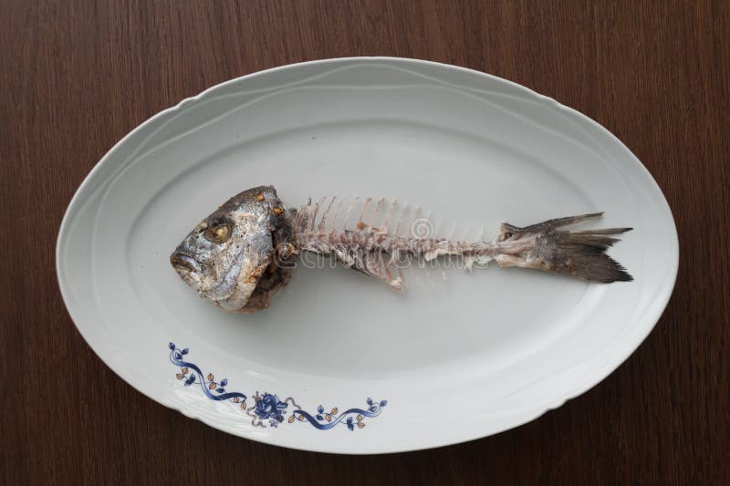 Fish Bone Left Overs with a Sliced Lemon on a White Oval Plate. Stock ...