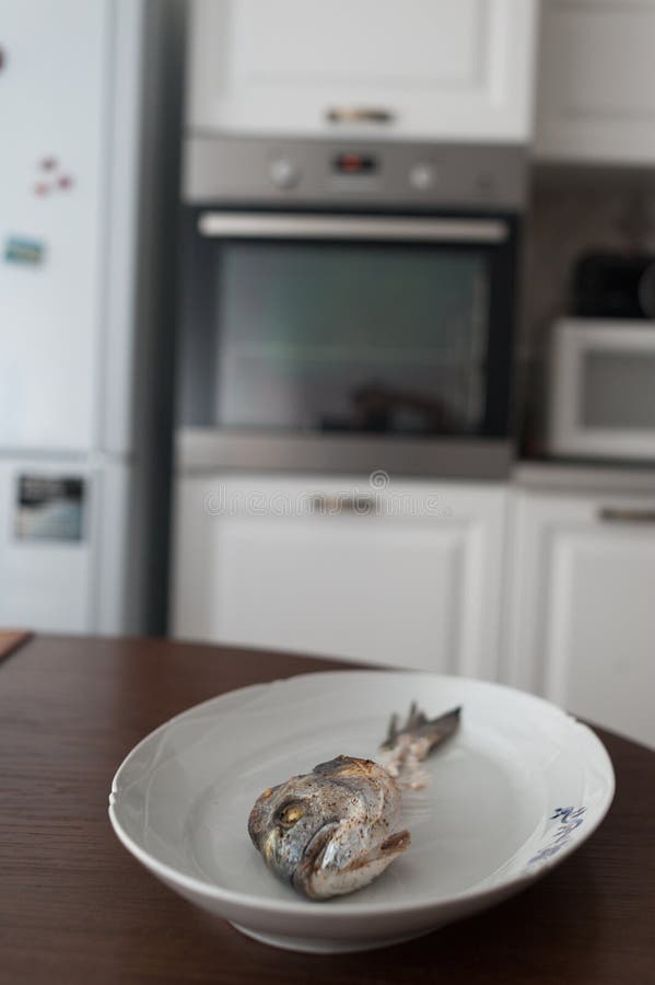 Fish Bone Left Overs with a Sliced Lemon on a White Oval Plate. Stock ...