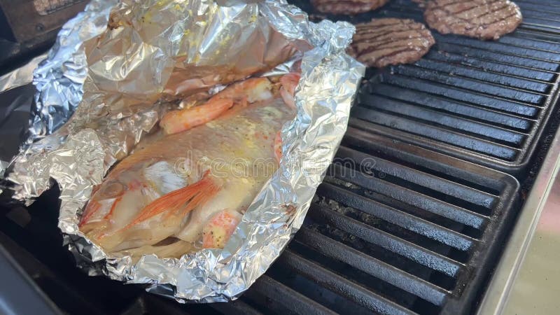 The Fish is Red and White Inside Fry Red Perch Fish on Foil Over an ...