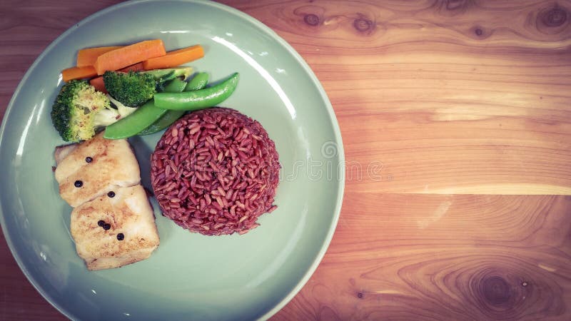 Fish Steak with Brown Rice and Vegetables on Wood Background Editorial ...