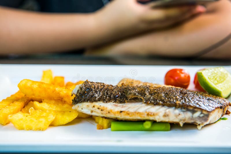 Fish steak on white plate stock image. Image of dining - 176416703