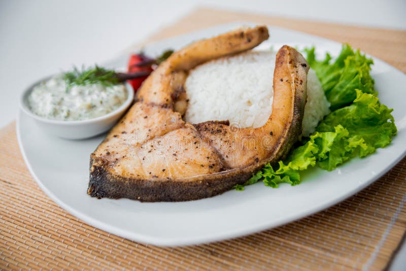 Fish Steak with Rice and Sauce on a White Plate. Stock Image - Image of ...