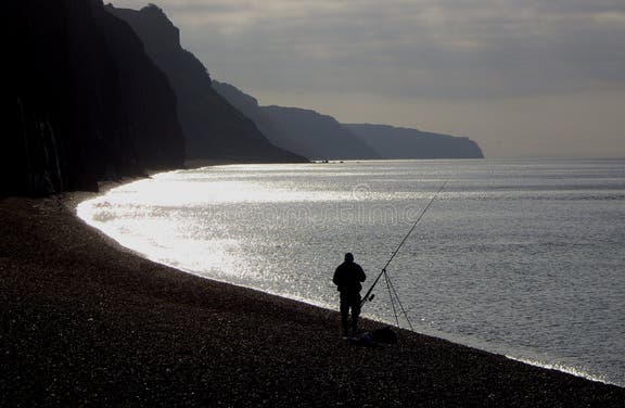 Fisherman angling on beach stock image. Image of person - 20583777