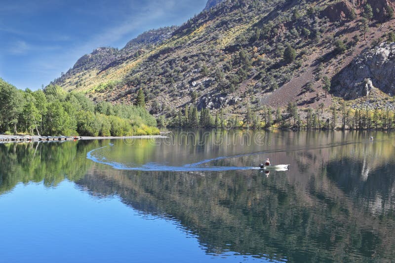 A Fisherman in a Boat in the Middle of the Lake Stock Photo - Image of ...