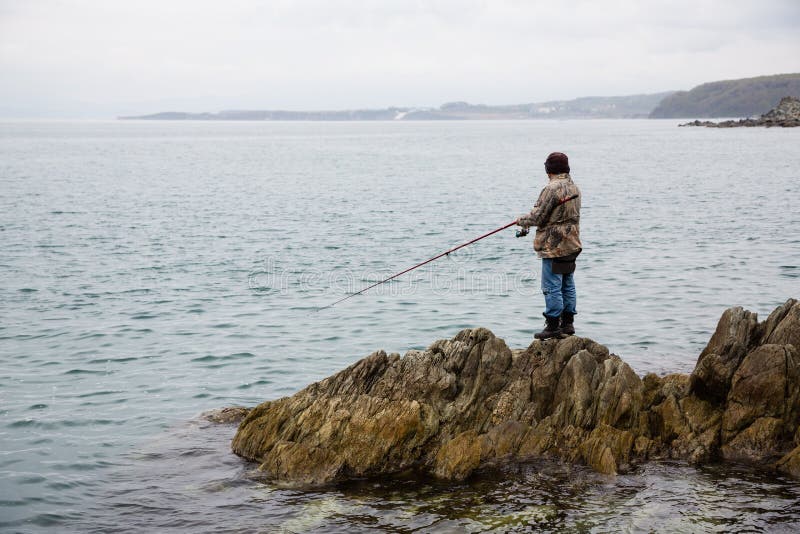 Fisherman Catches Fish on the Rocks Stock Image - Image of catch ...