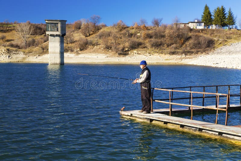 Fisherman Fishing on Blue Lake Stock Photo - Image of dawn, hobby: 65253616