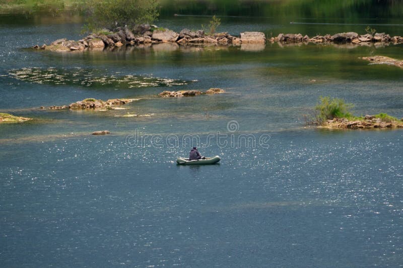 Fisherman Floats Down the Blue River in an Inflatable Boat, Catching ...
