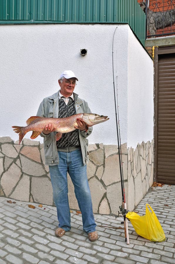 Fisherman holding a pike stock photo. Image of fisherman - 26954332