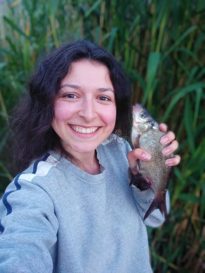 The Fisherman Holds in His Hand a Fish that Has Just Been Pulled Out of ...