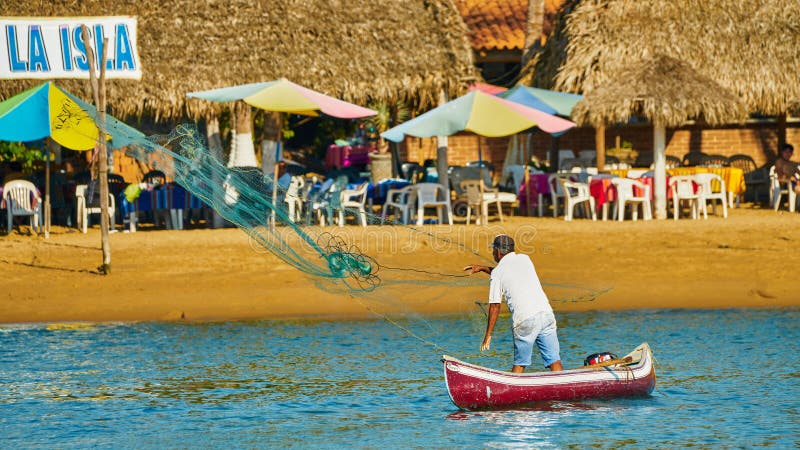 Fisherman in His Canoe Using a Net To Fish in the Middle of the Sea ...