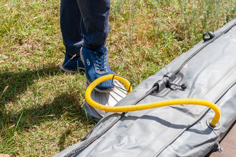 A Fisherman Pumps an Inflatable Boat with a Foot Pump. Inflatable Boat ...