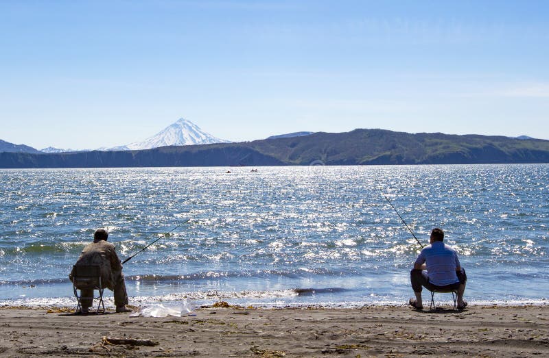 The Fisherman Sitting and Fishing on the Beach of Pacific Ocean Stock ...