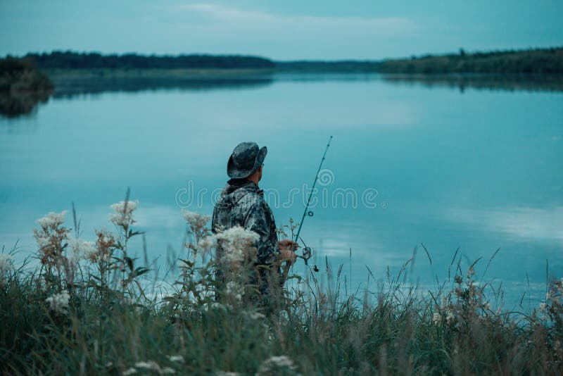 Fisherman Standing in Grass and Fishing, Back View Stock Photo - Image ...