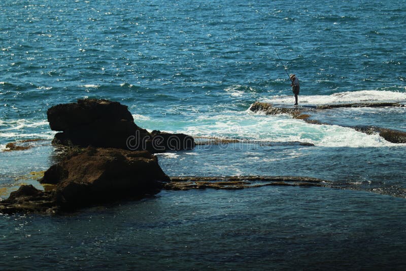 Fisherman Standing on a Rock on the Beach Stock Photo - Image of ...
