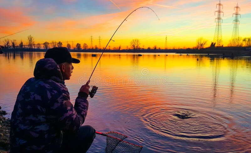 Fisherman at Sunset Who is Catching a Fish Stock Photo - Image of ...