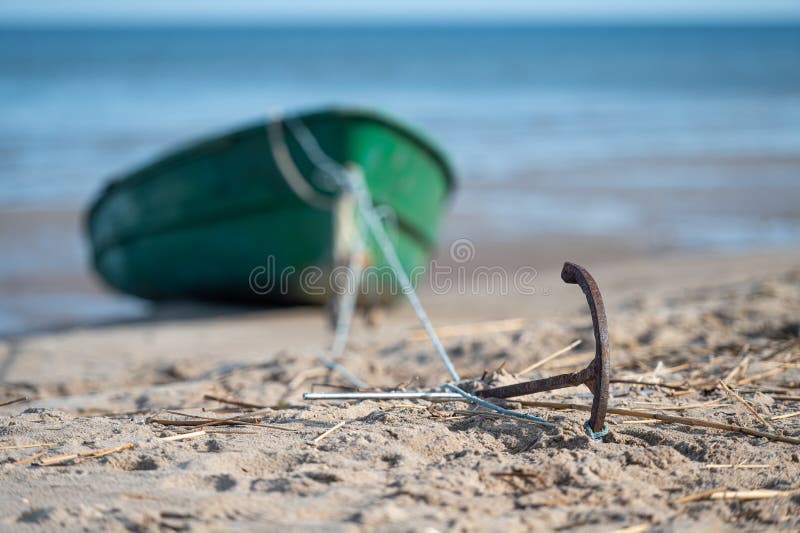Fishing Boat on a Sandy Beach with a Rope and Anchor in the Foreground ...