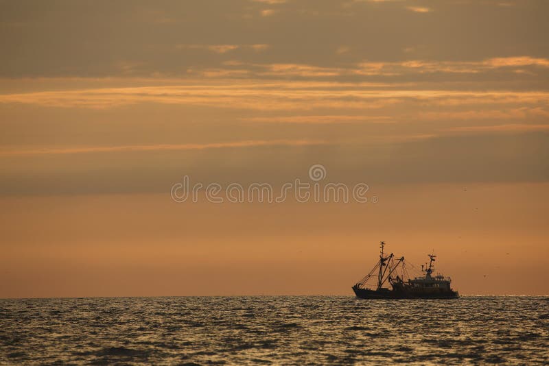 A fishing boat at sunset stock photo. Image of boat - 159839456