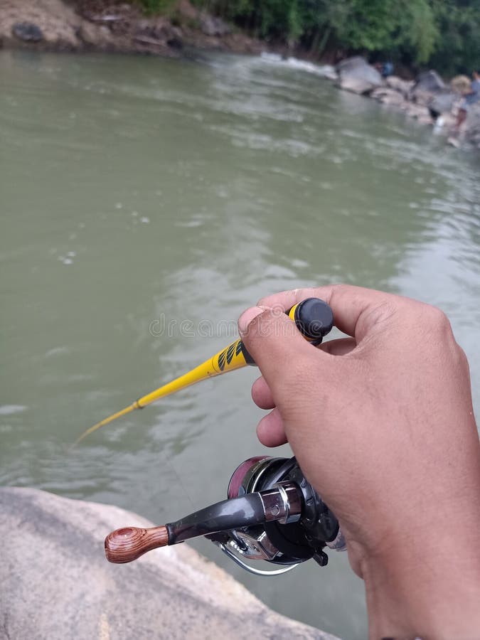Fishing for Fish Using a Yellow Rod with a String Reel in the River ...