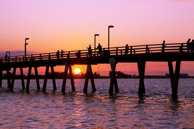 Fishing Off the Pier at Sunset Stock Photo - Image of fishermen, action ...