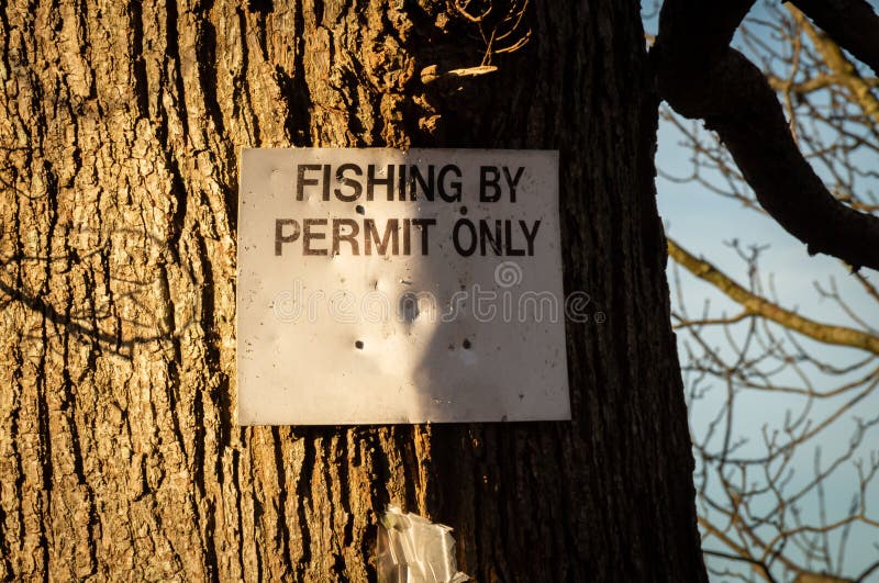 Fishing by Permit only Sign Attached To a Large Tree in the Winter Sun ...