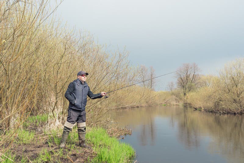 Fishing on the river bank stock photo. Image of sport - 240794698