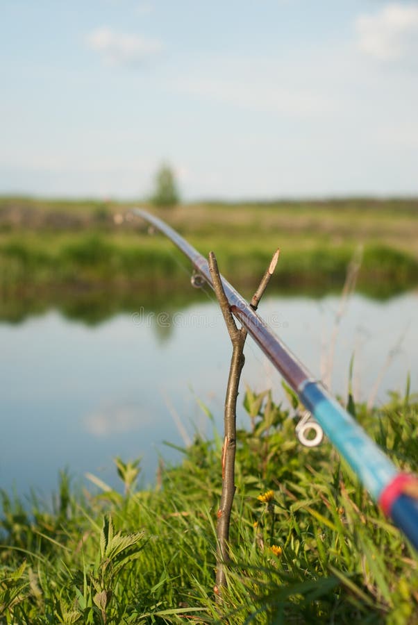 Fishing Rod on the Bank of the River, the Sky Reflected in the Water of ...