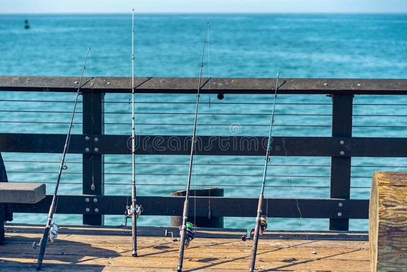 Fishing Rods on a Pier, Blue Sea and Blue Sky Backgrounds Stock Image ...