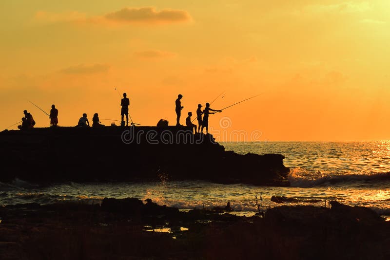 Fishing at SunsetÑŽ People Catch Fish at Sunset. Stock Image - Image of ...